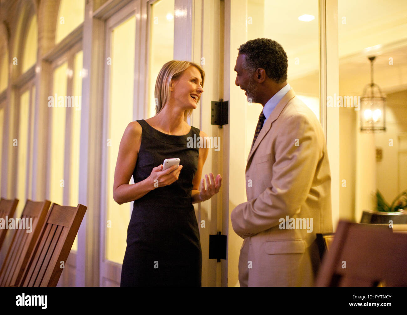 Two business partners talking on the balcony of their hotel Stock Photo ...