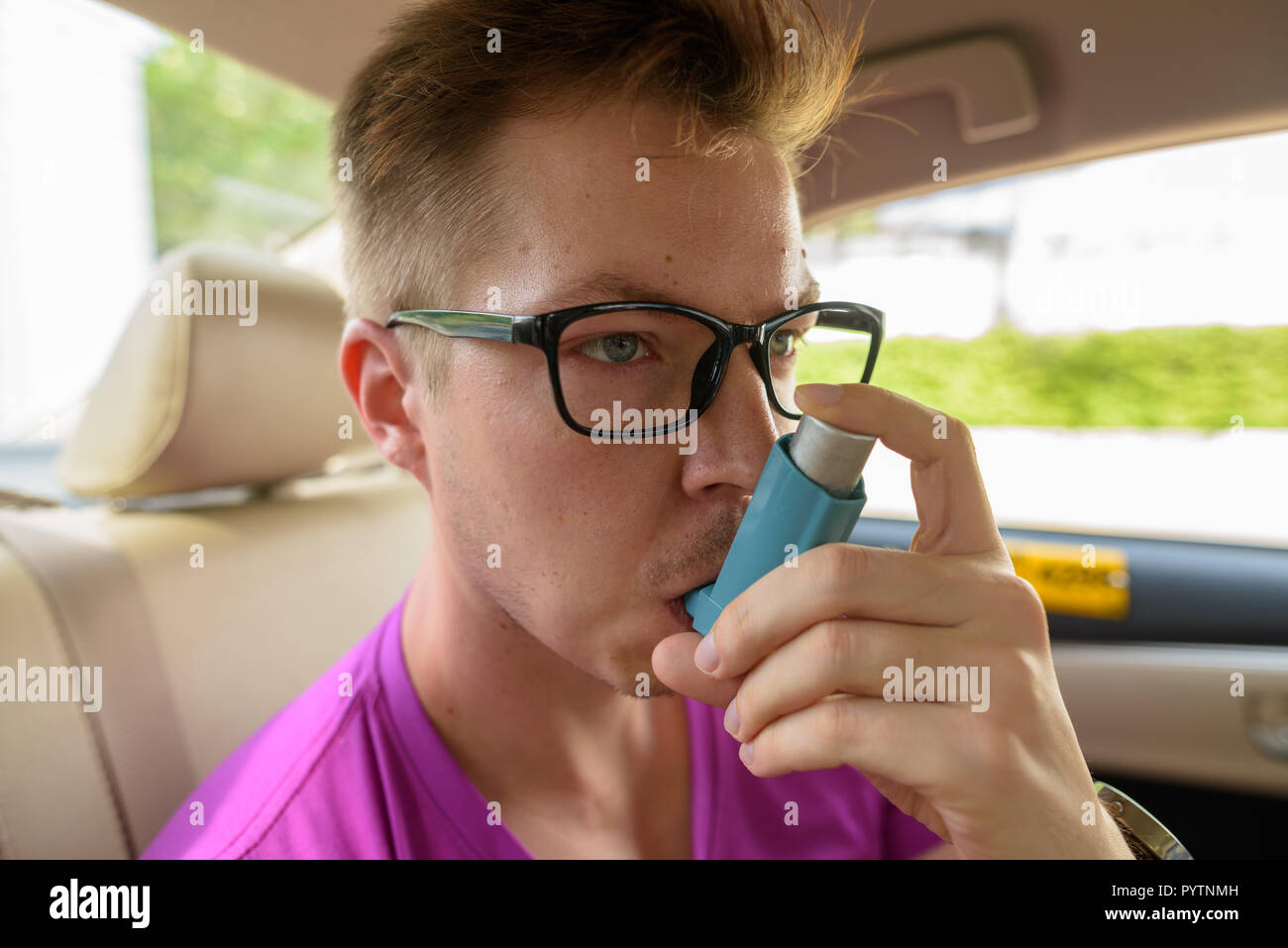 Face of man using asthma inhaler in back seat of car Stock Photo - Alamy