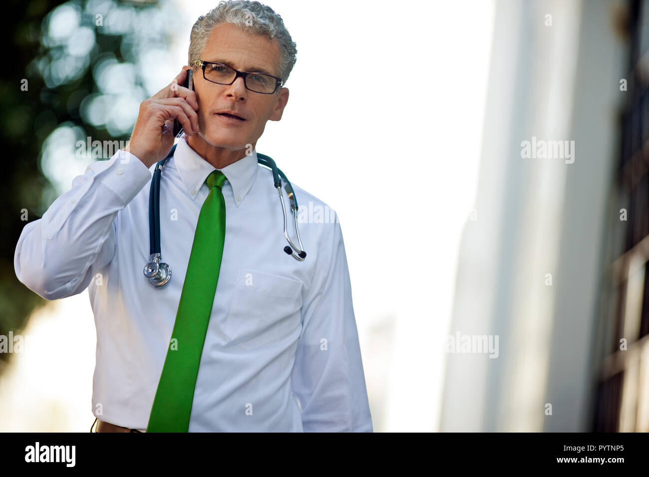 Doctor talking on mobile walking hi-res stock photography and images ...