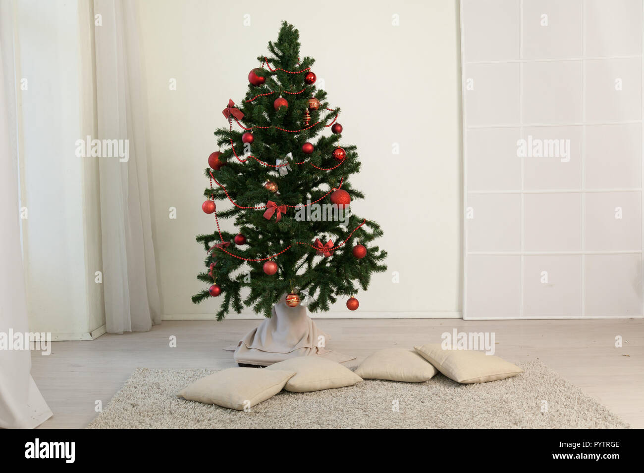 Christmas tree in white interior with stocking-stuffers Stock Photo - Alamy