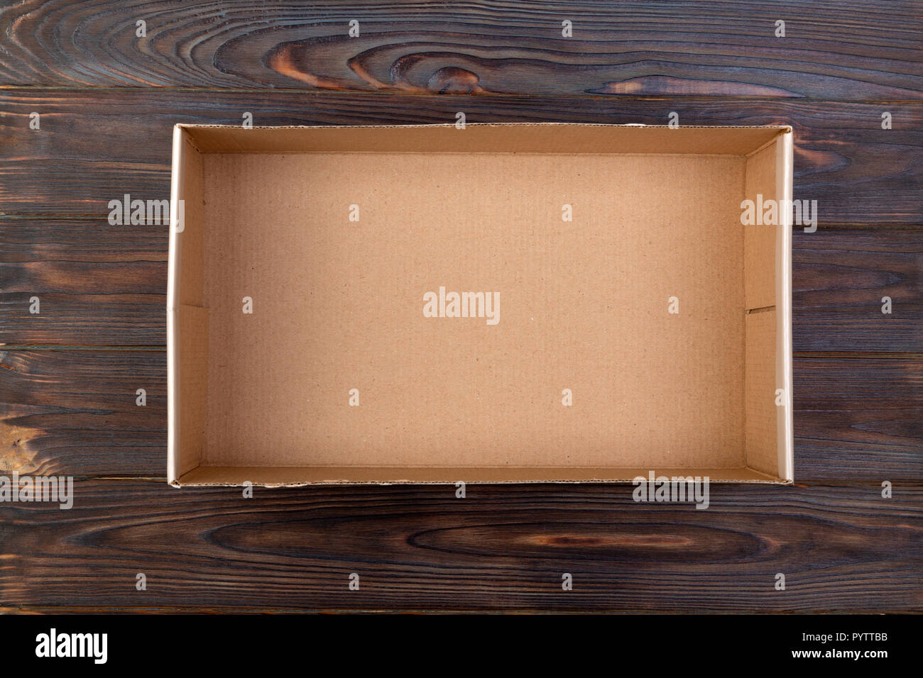 Open Cardboard box on a dark table, wooden background. top view Stock ...