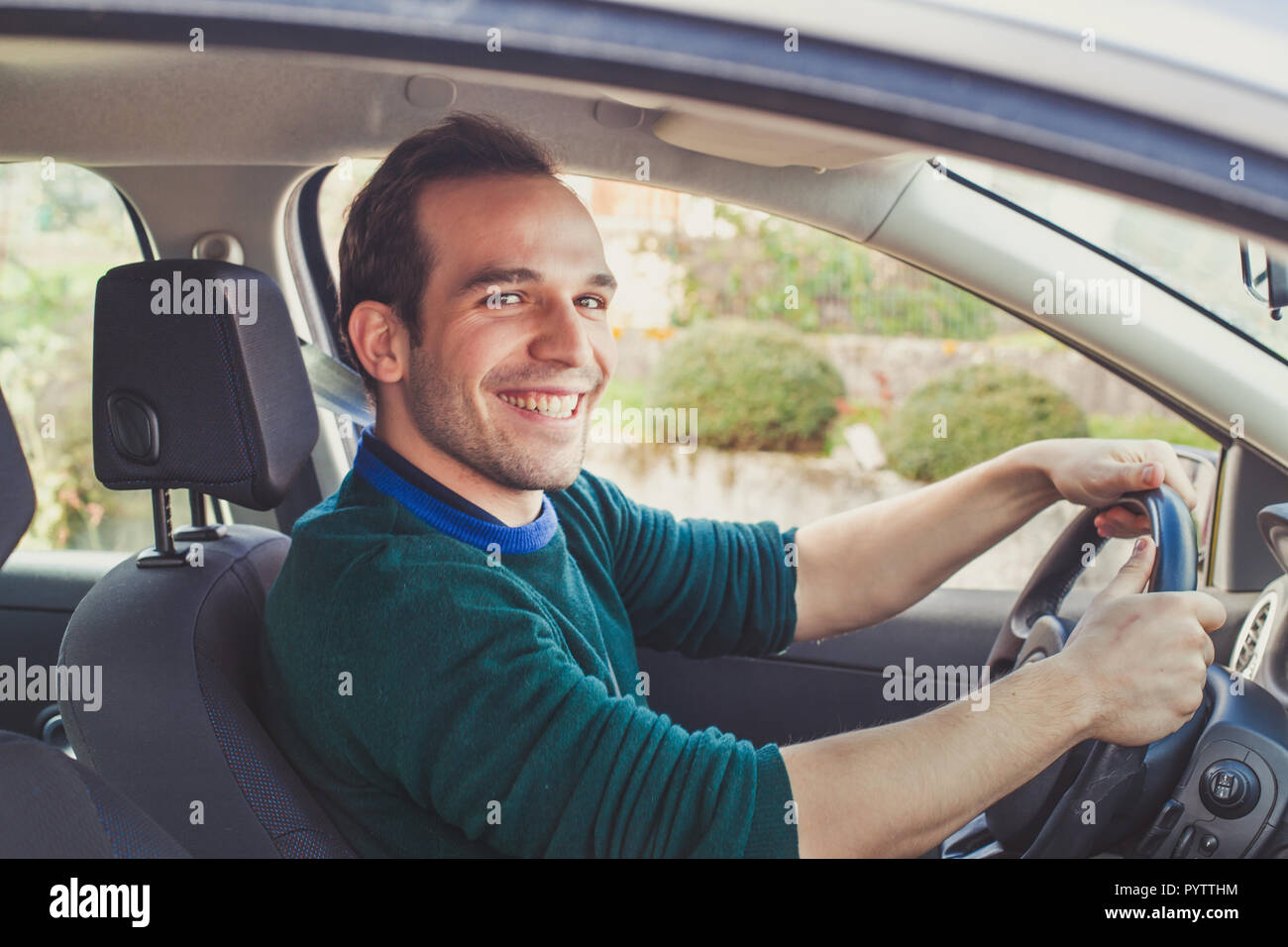 Portrait of happy driver in car. Smiling young man looking at camera ...
