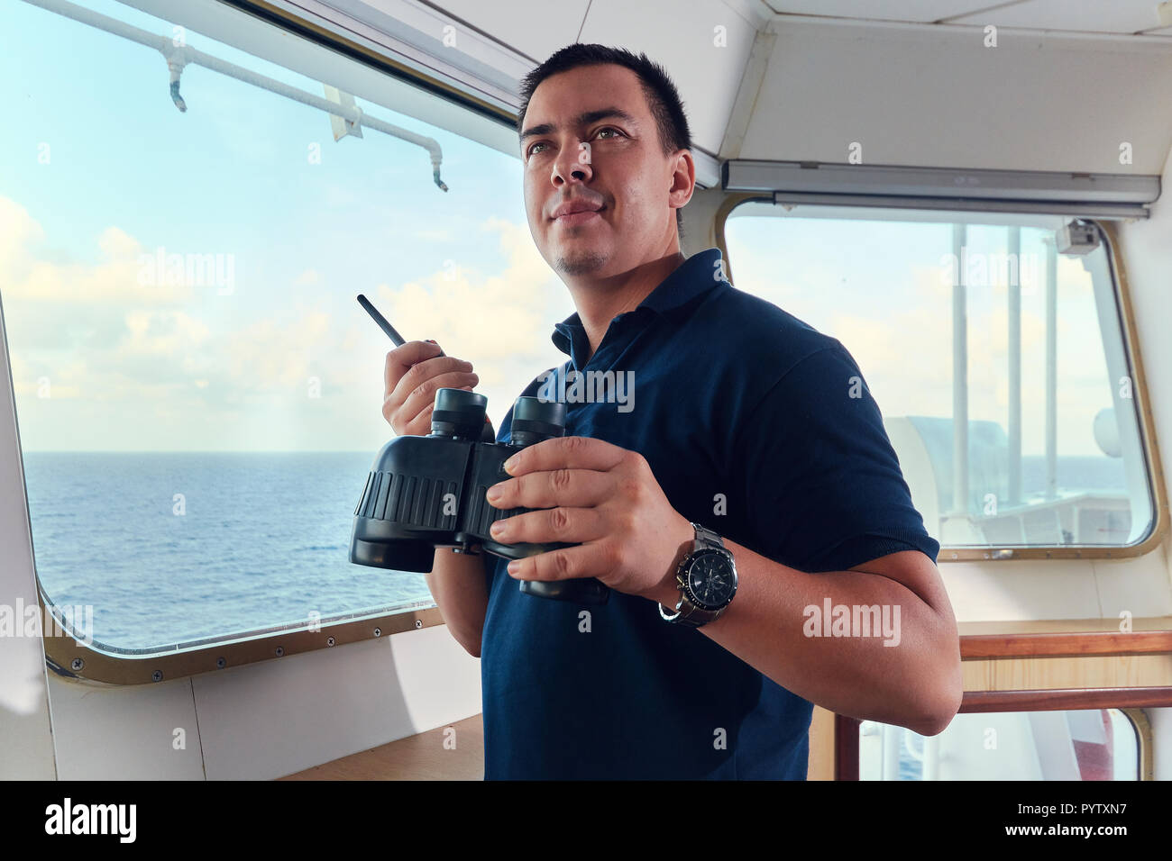 Navigation offcier / Pilot on the bridge of a ship underway with ...