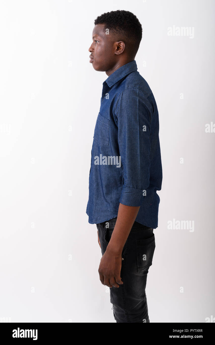 Profile view of young black African man standing against white b Stock ...