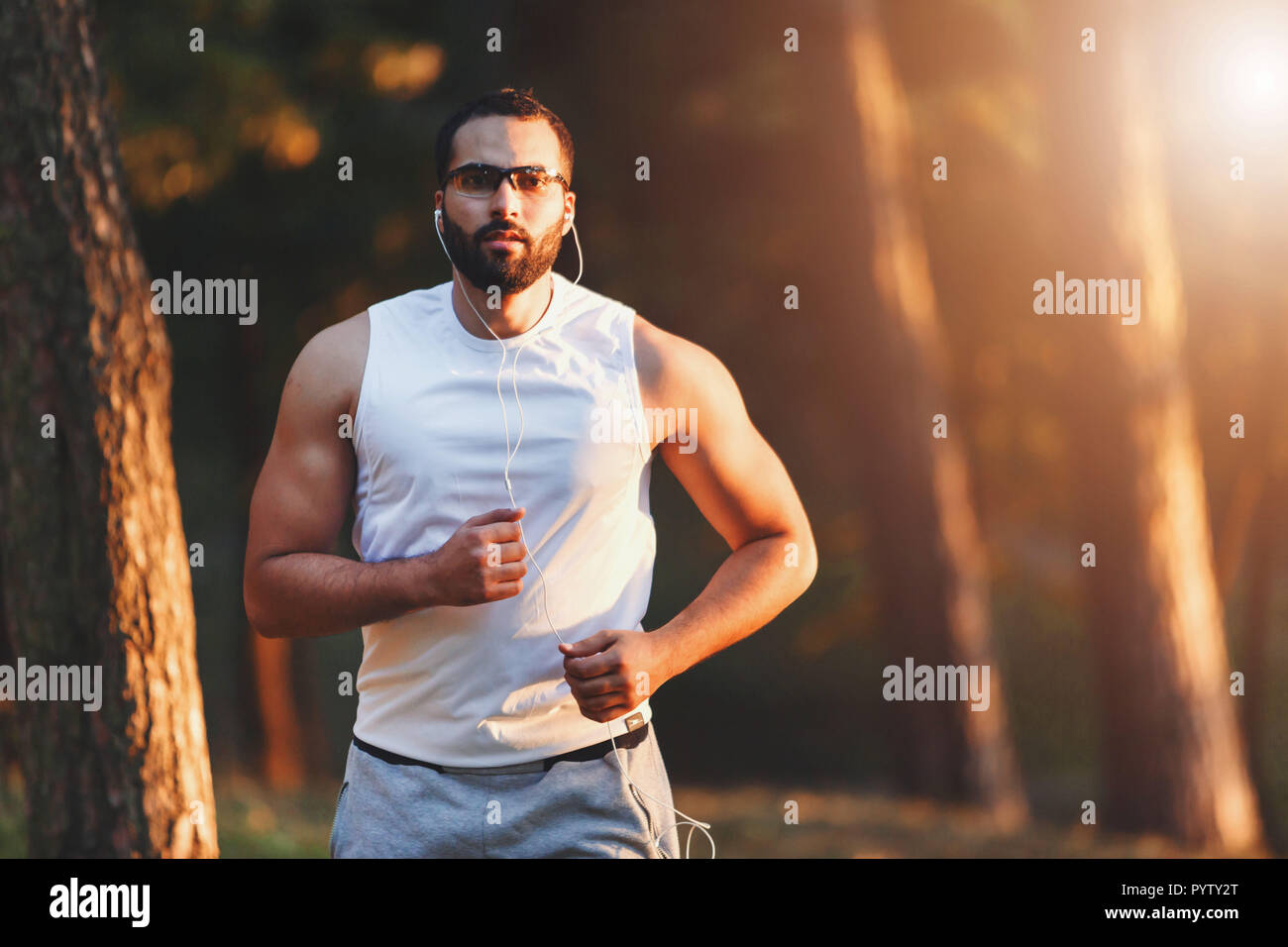 Multicultural handsome bearded man in sportswear listening his favorite ...