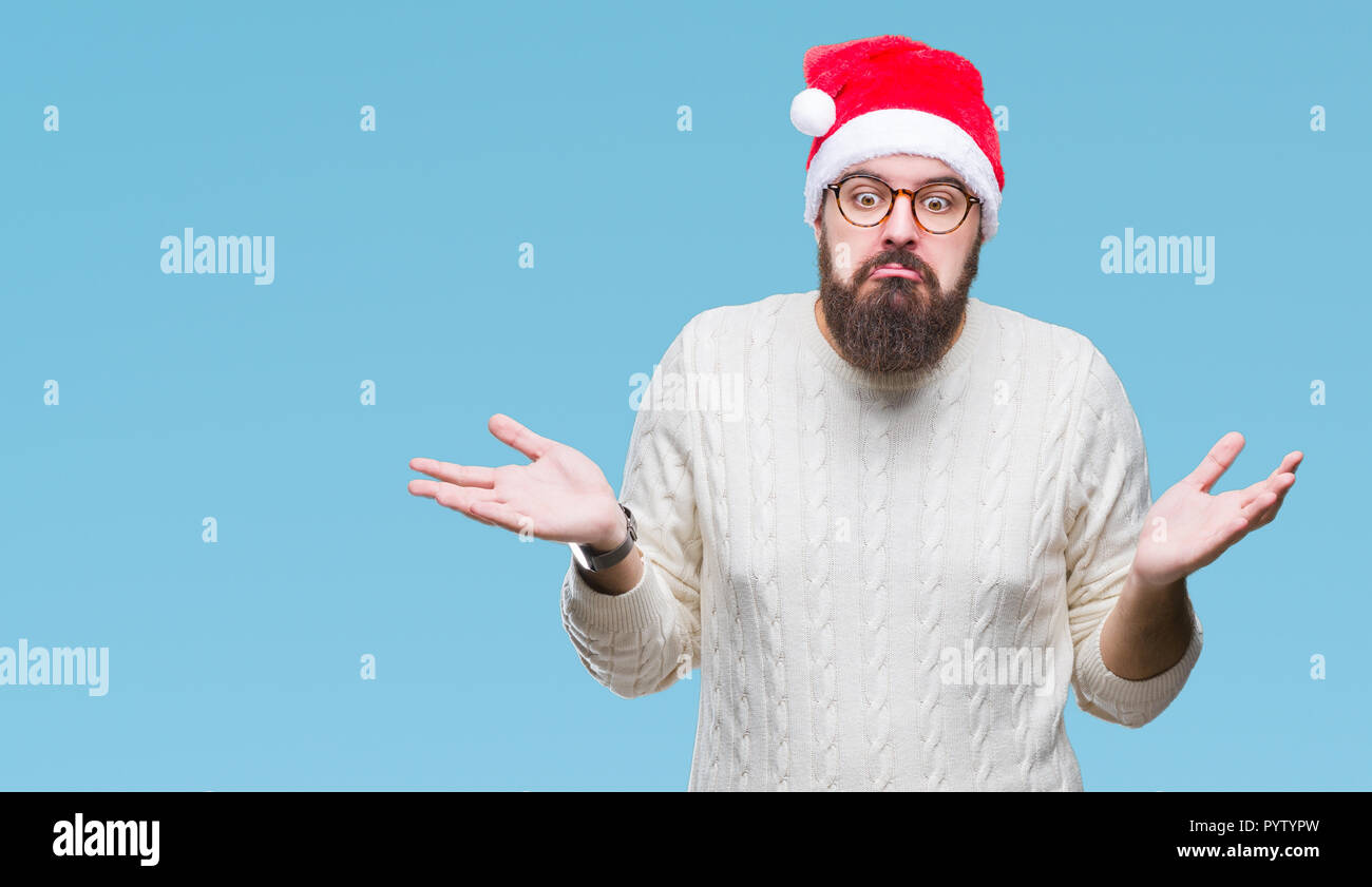 Young caucasian man wearing christmas hat and glasses over isolated ...