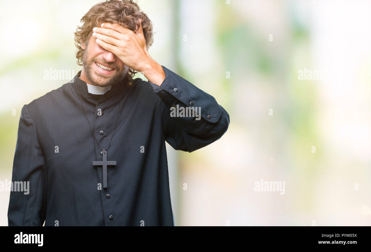 Handsome hispanic catholic priest man over isolated background smiling ...