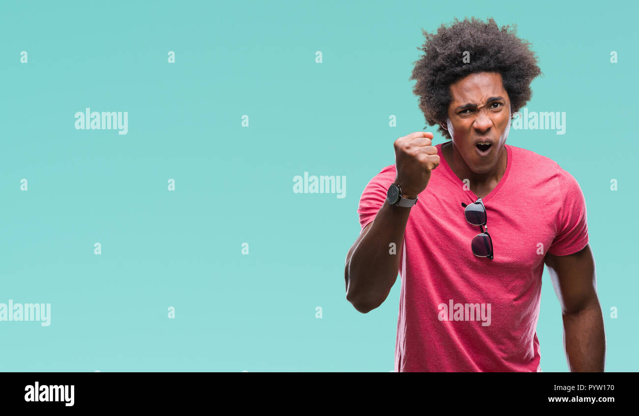 Afro american man over isolated background angry and mad raising fist ...