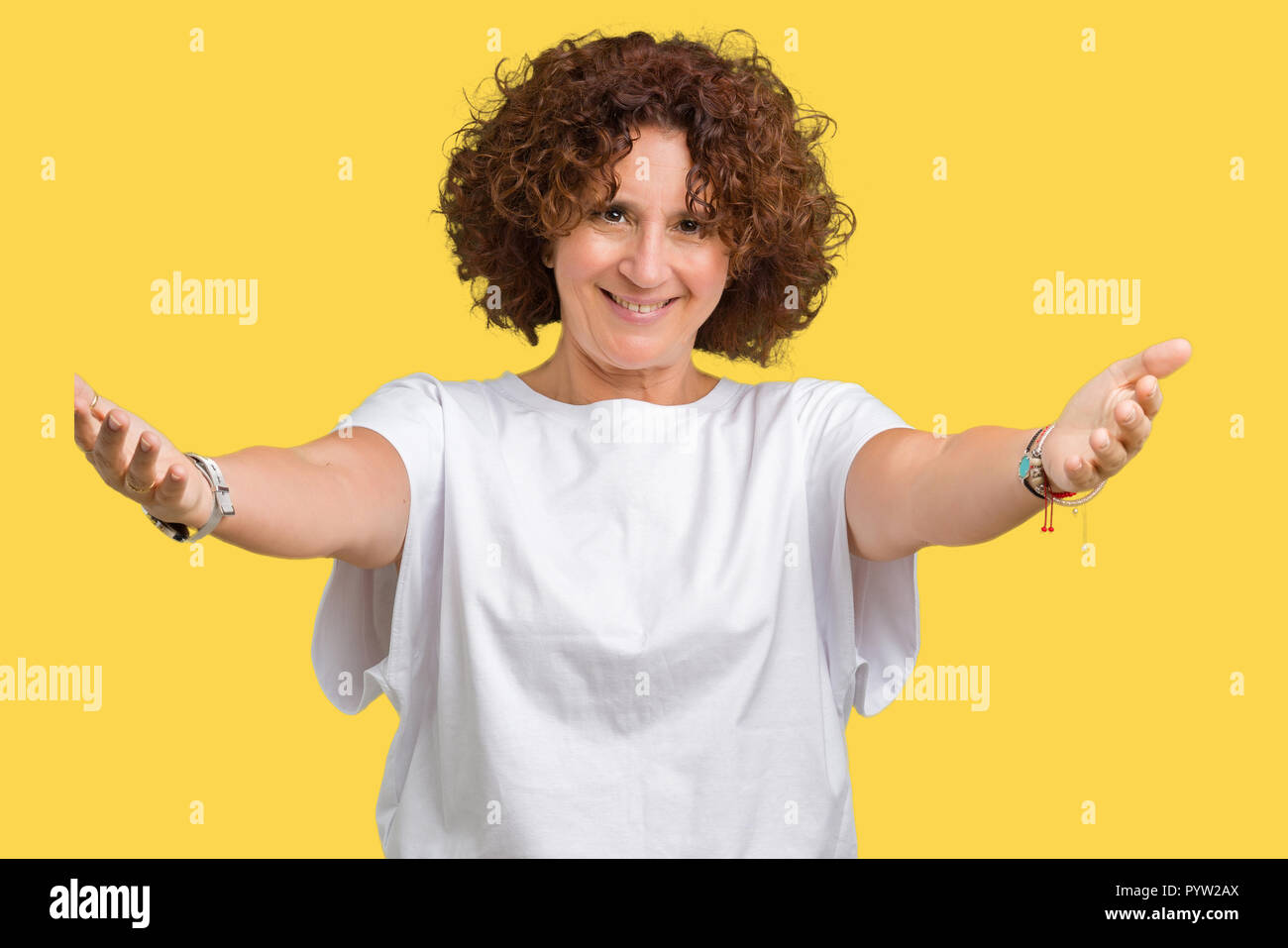 Beautiful middle ager senior woman wearing white t-shirt over isolated ...