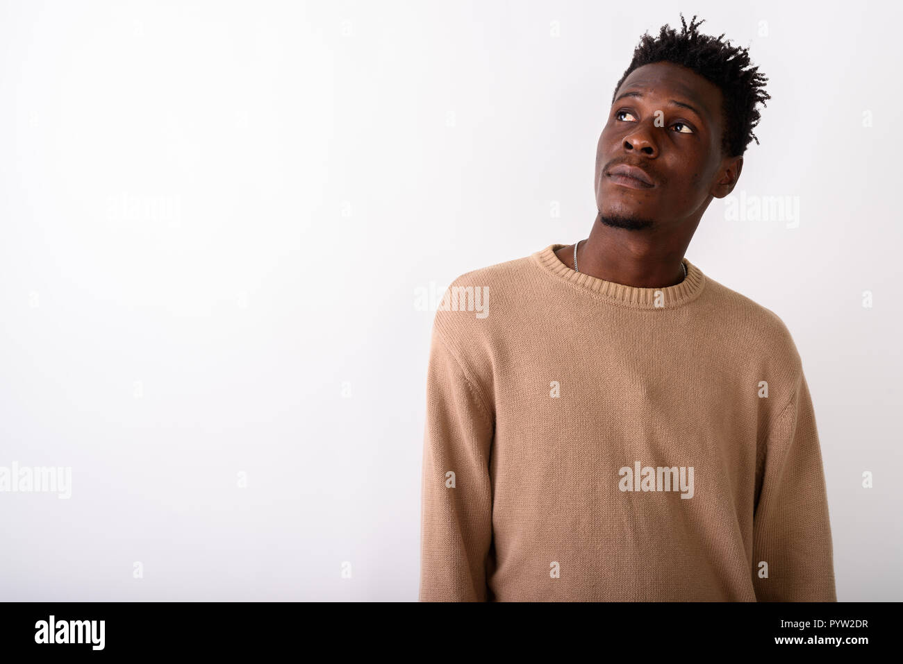 Studio shot of young black African man thinking while looking up Stock ...