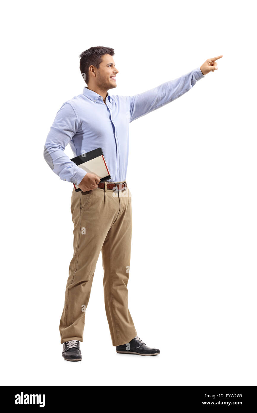 Full length shot of a young man holding books and pointing isolated on ...