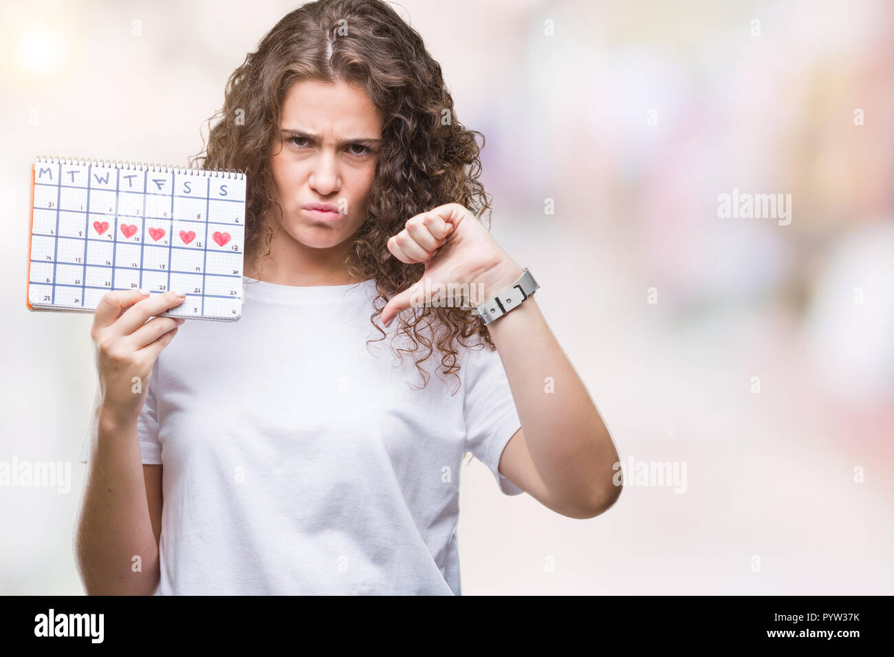 Young brunette girl holding menstruation calendar over isolated ...
