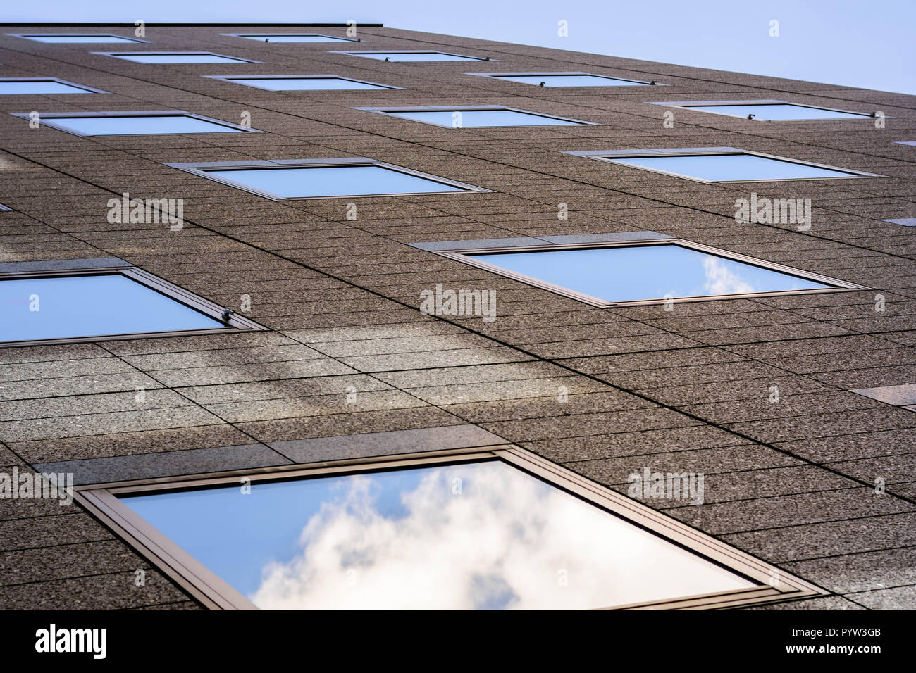 Brown office building exterior with square mirror patterns reflecting ...