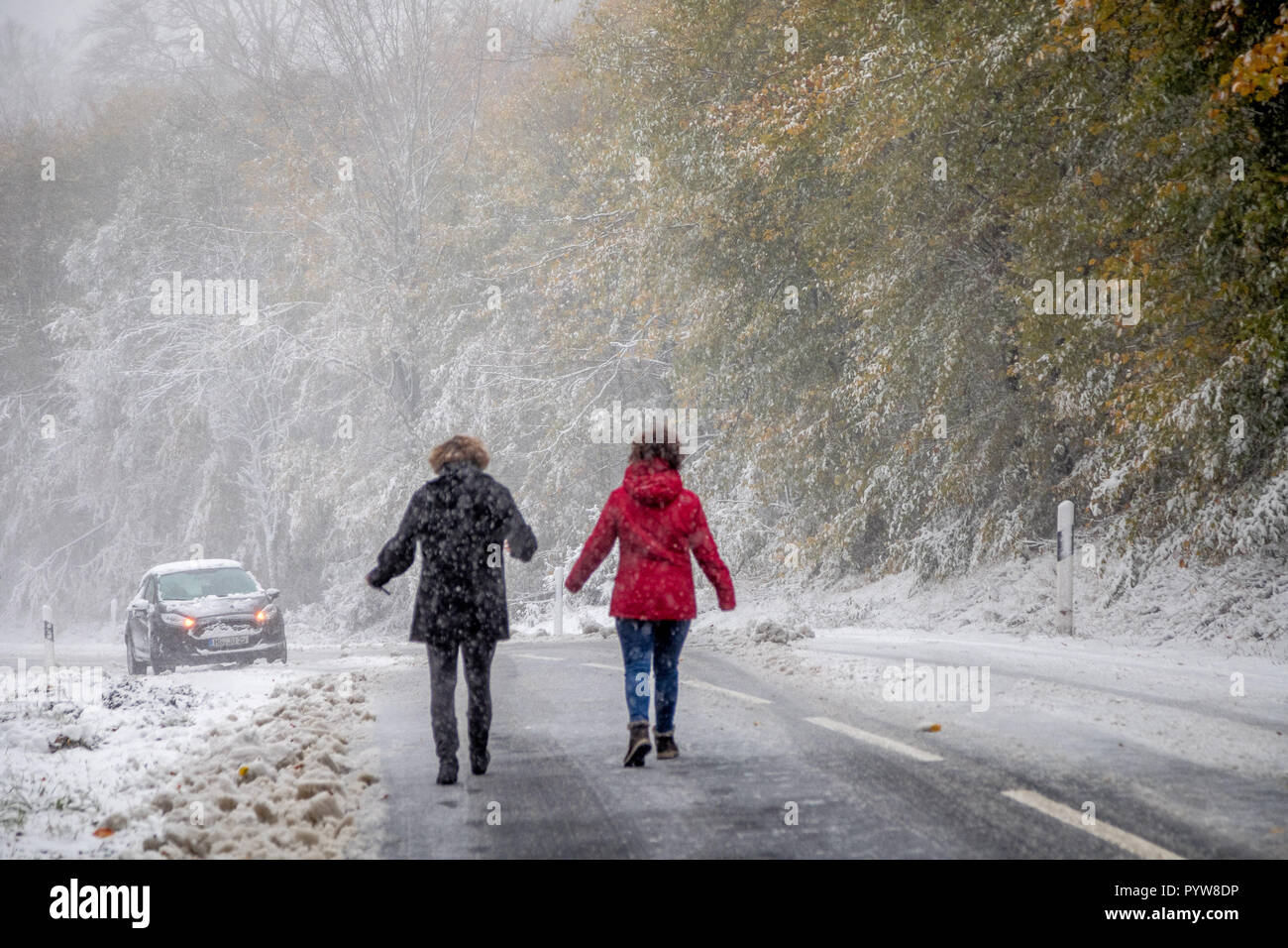 Schmitten, Germany. 30th Oct, 2018. Two women walk down the slippery ...