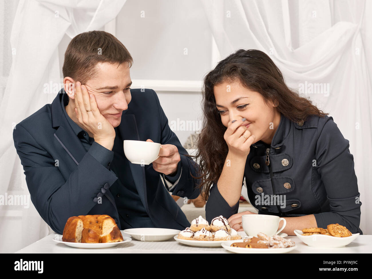 romantic couple drinking tea with cookies and talking Stock Photo - Alamy