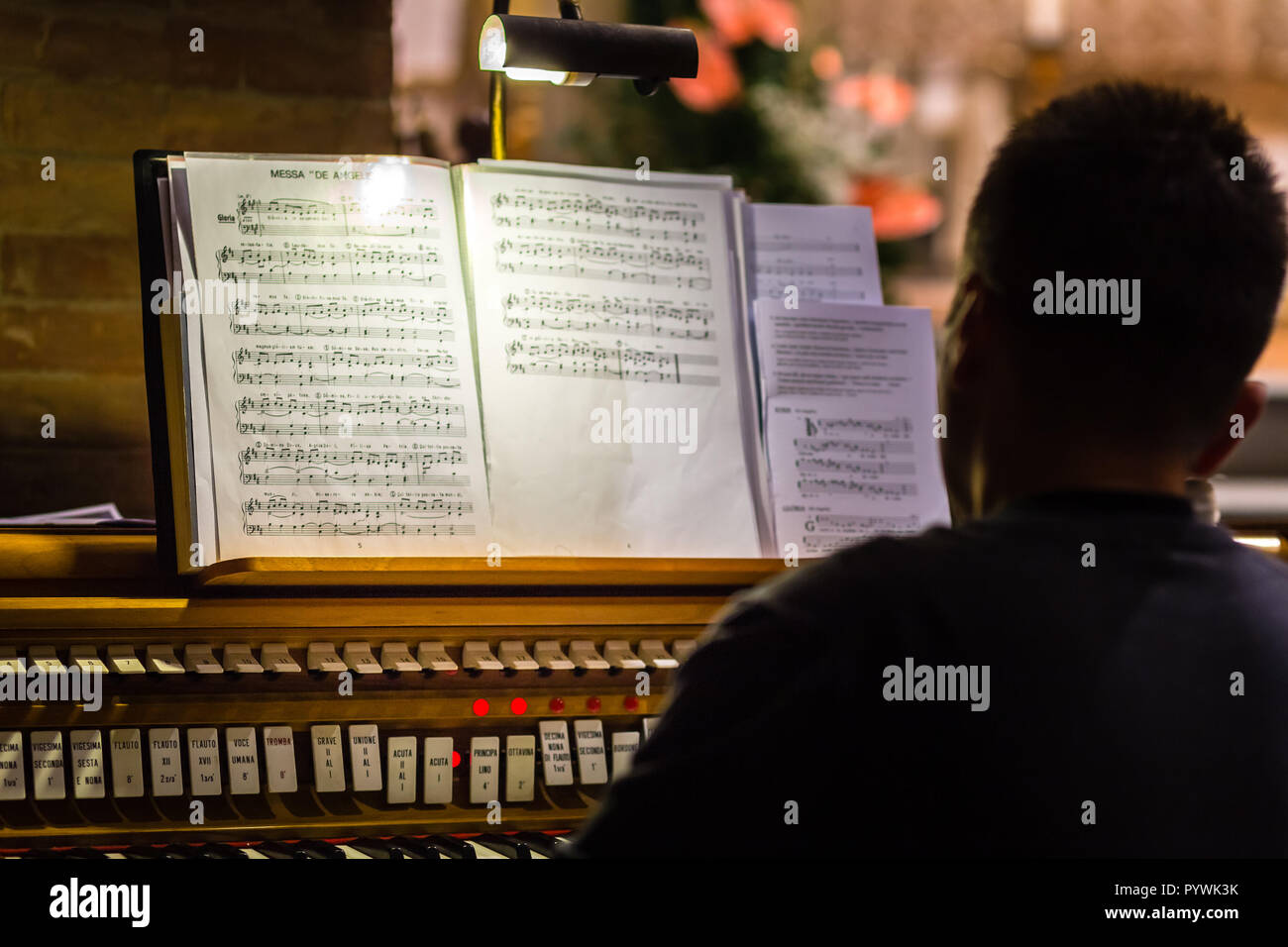 back of pianist looking at score on church organ Stock Photo - Alamy