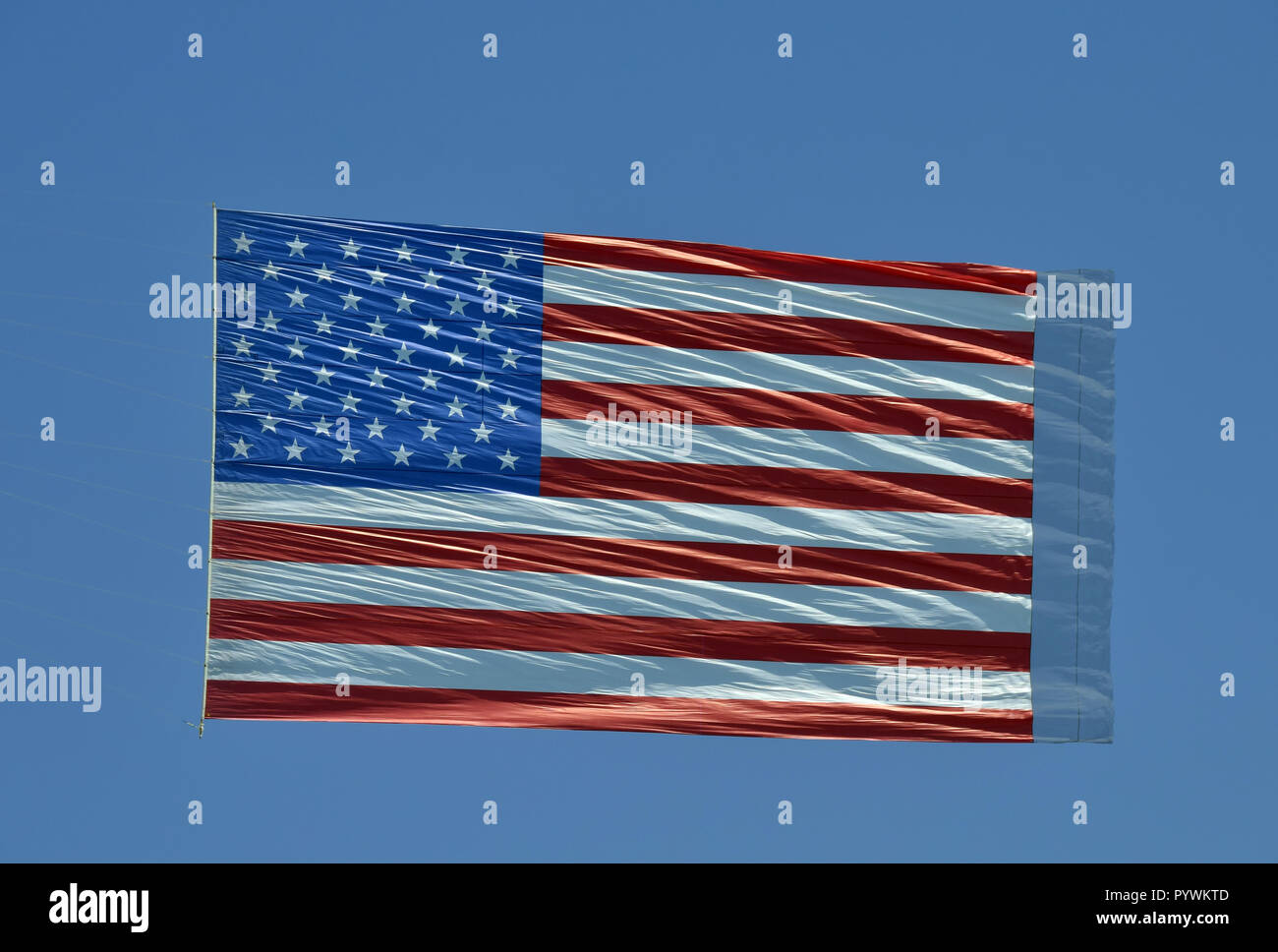 Giant American flag airborne as aerial banner against blue sky Stock ...