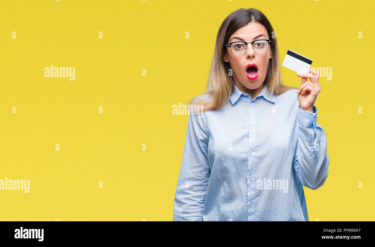 Young beautiful business woman holding credit card over isolated ...