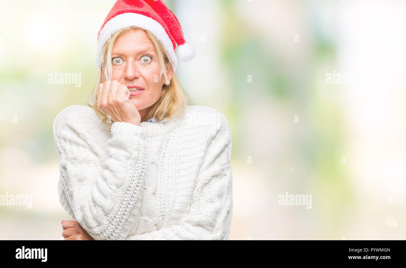Middle age blonde woman wearing christmas hat over isolated background ...