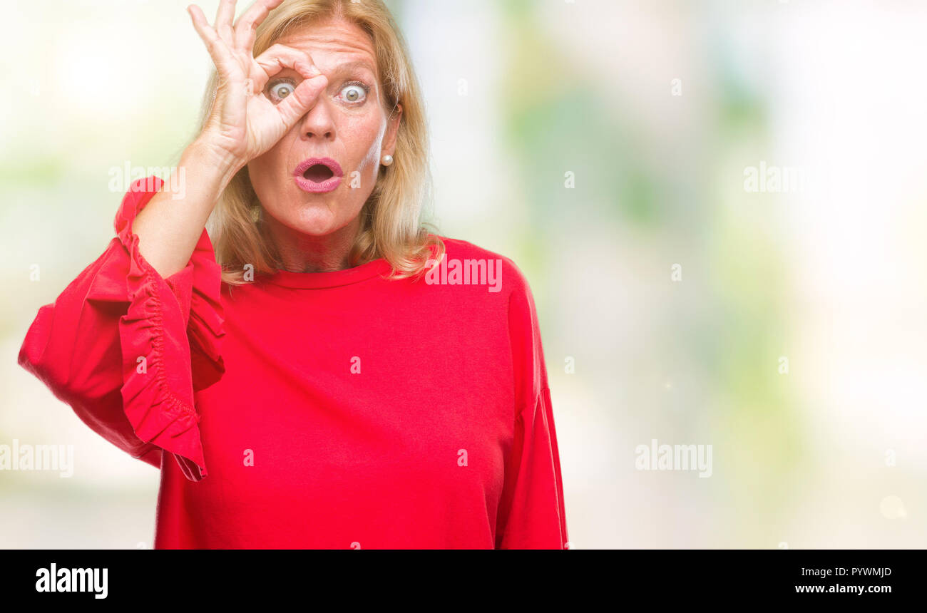 Middle age blonde woman over isolated background doing ok gesture ...