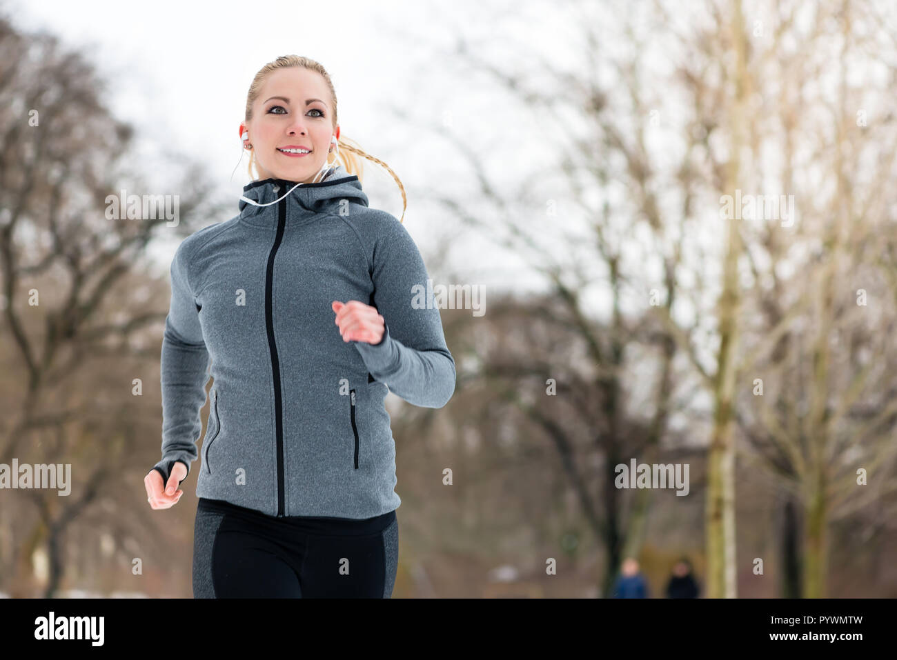 Woman running down a path on winter day in park Stock Photo - Alamy