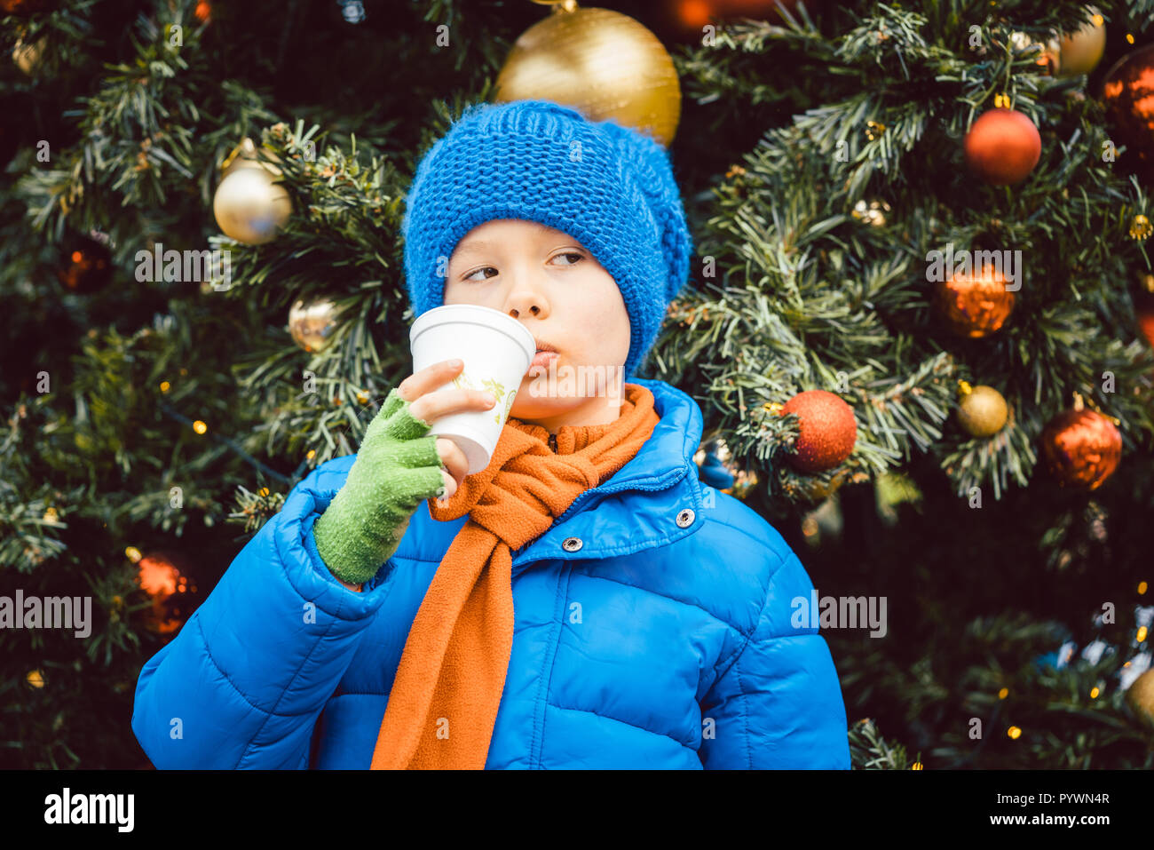 Young boy enjoying a drink on the Christmas Market Stock Photo - Alamy