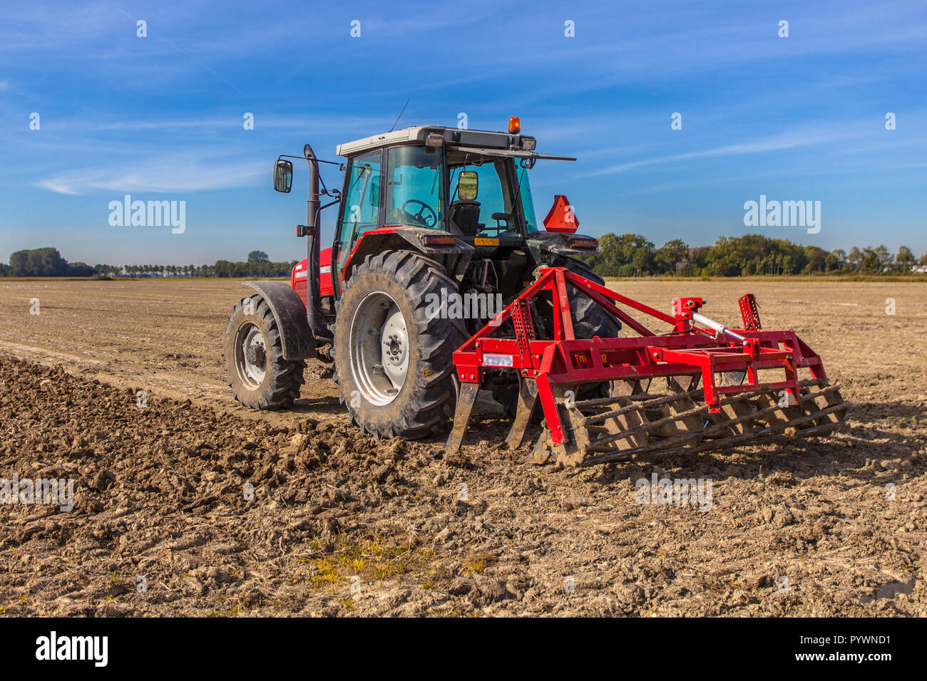Field being ploughed by tractor with Plough under Blue Sky. Farming ...