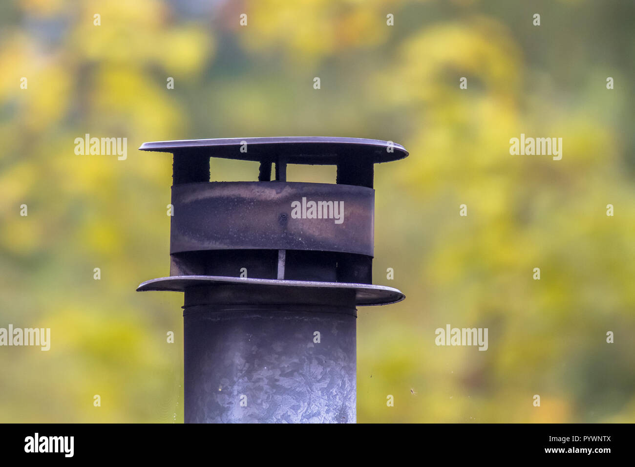 Metal chimney exhaust on a cottage with green leaf background Stock ...