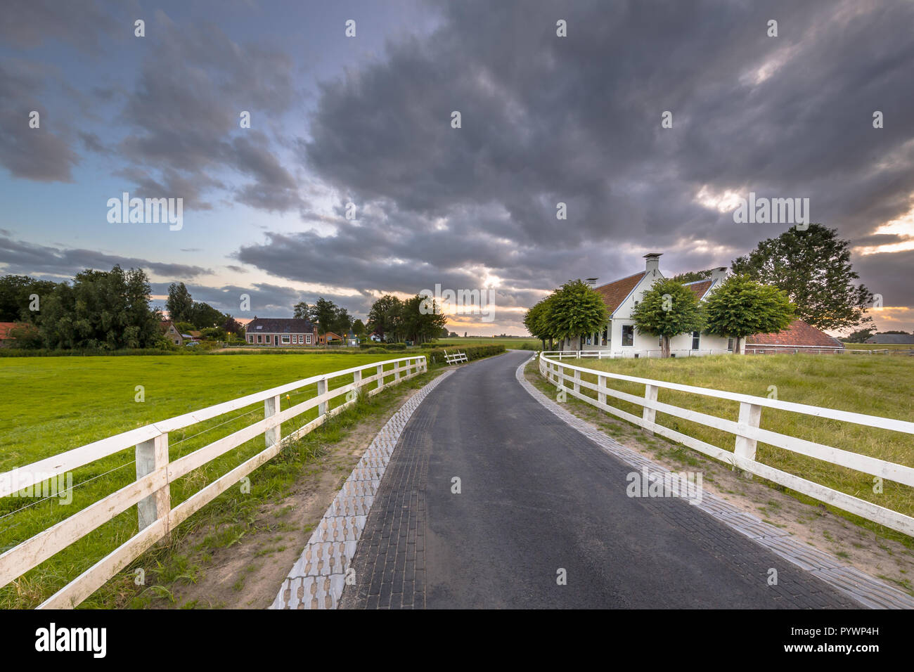 Road and fence in old dutch countryside of Reitdiep leading towards ...
