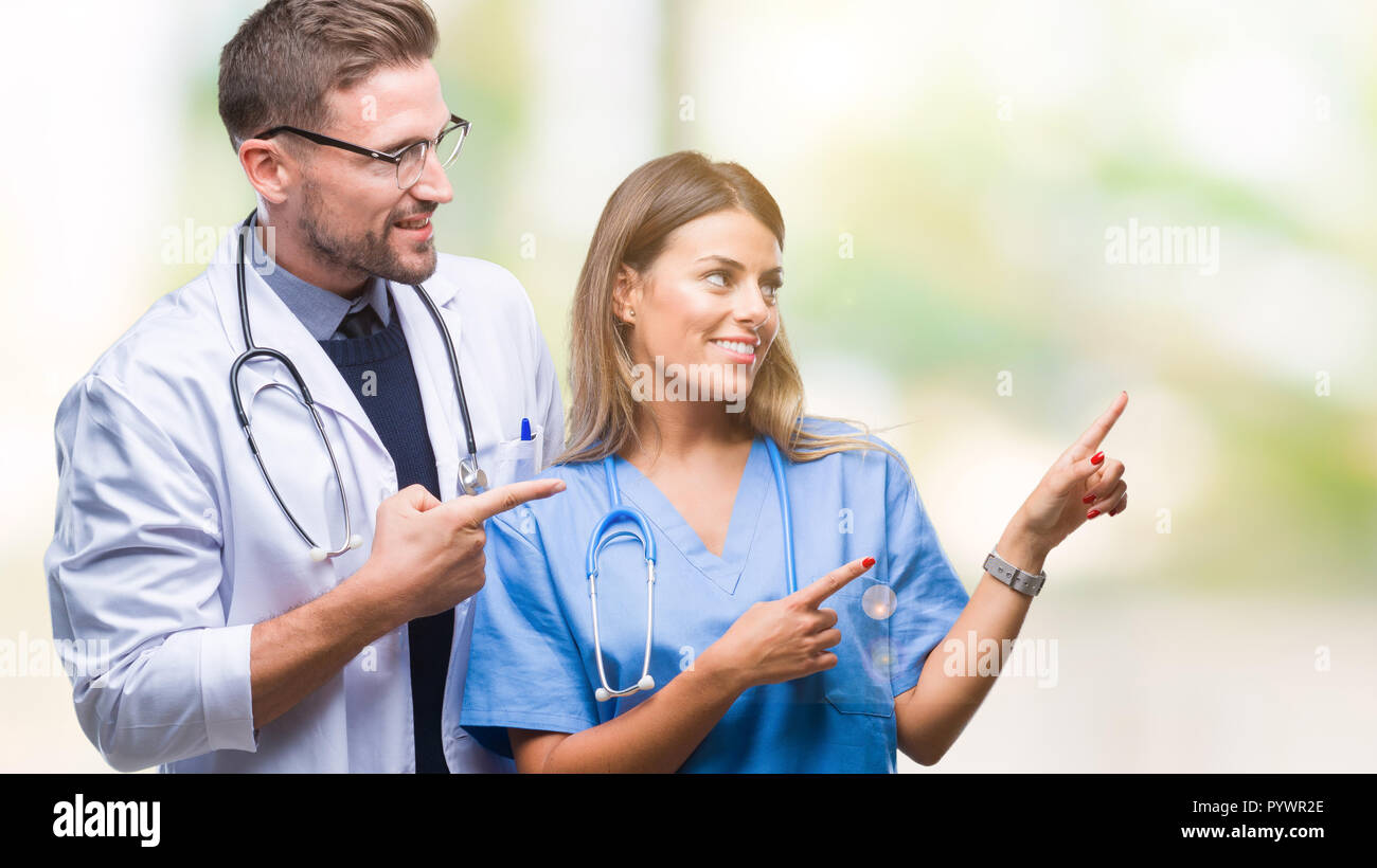 Young couple of doctor and surgeon over isolated background smiling and ...