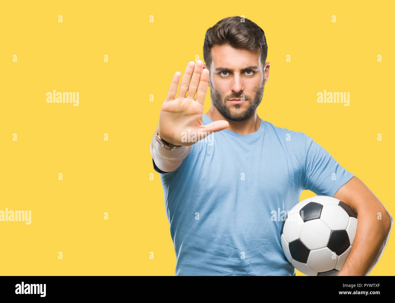 Young handsome man holding soccer football ball over isolated ...