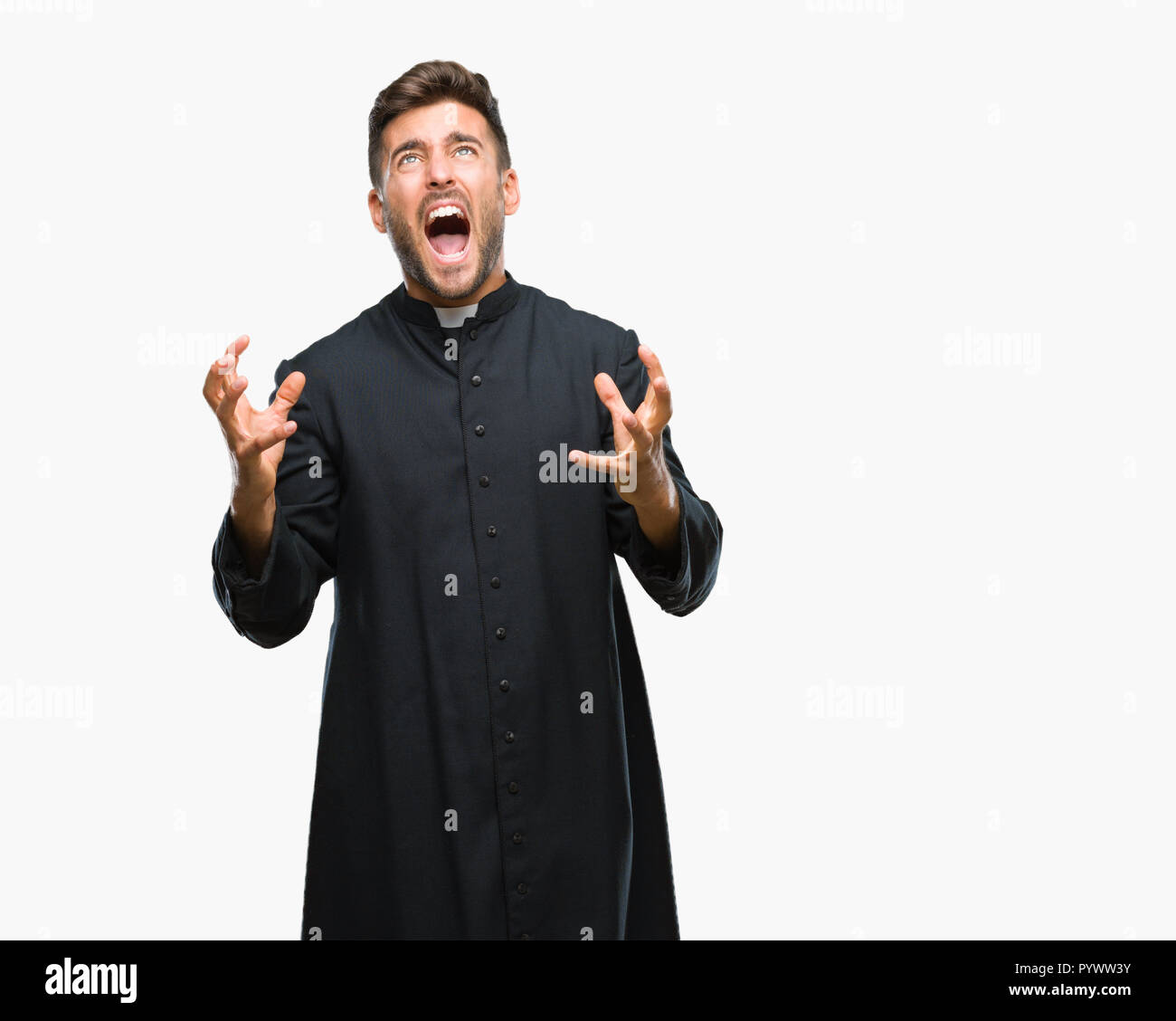 Young catholic christian priest man over isolated background crazy and ...