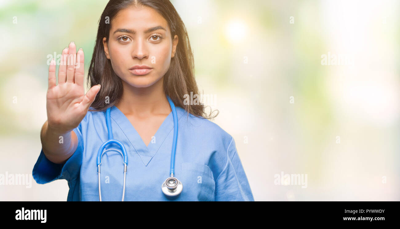 Young arab doctor surgeon woman over isolated background doing stop ...