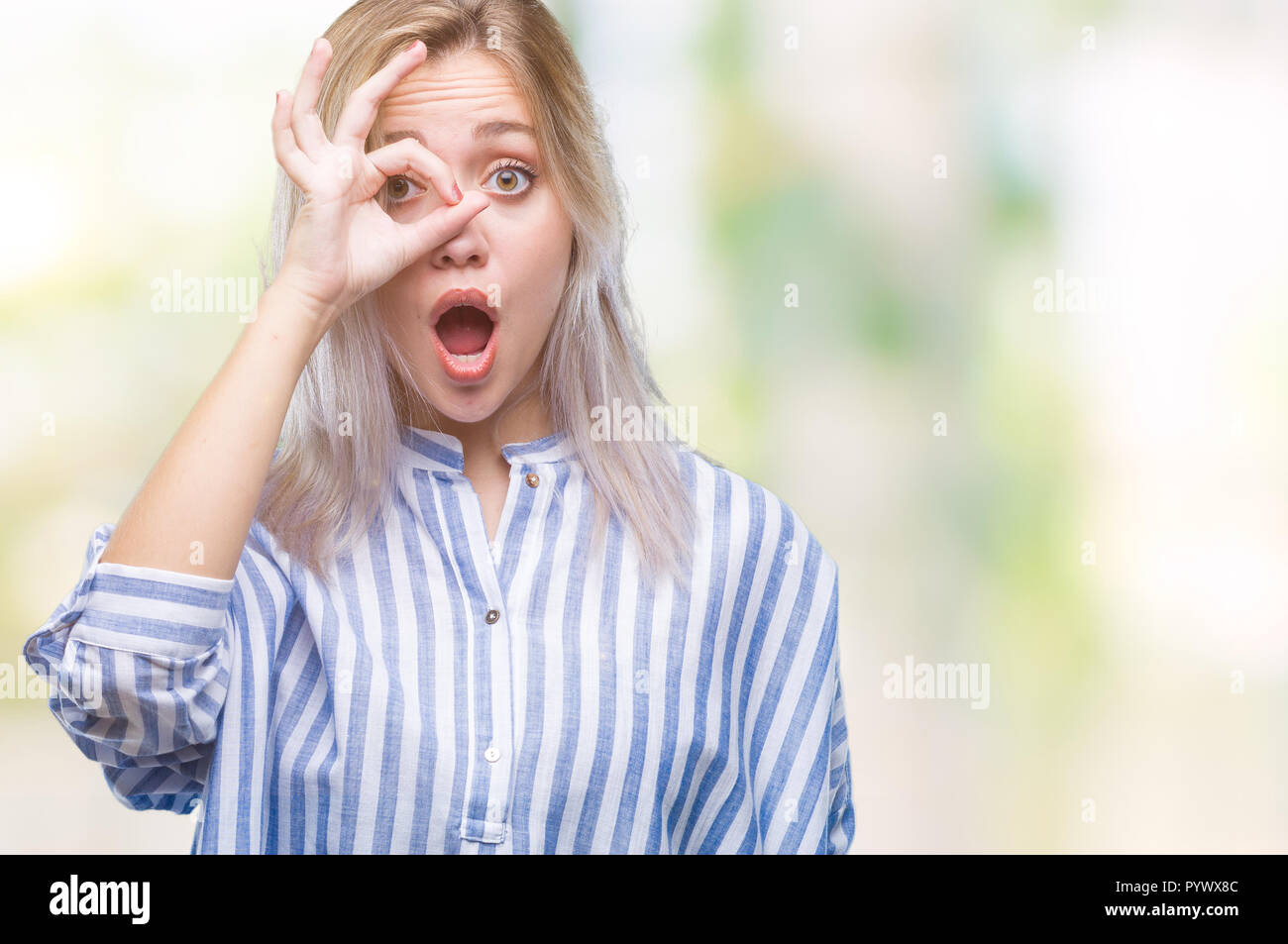 Young blonde woman over isolated background doing ok gesture shocked ...