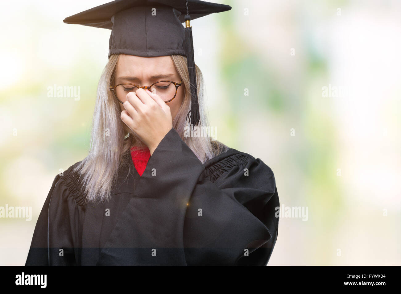 Young blonde woman wearing graduate uniform over isolated background ...