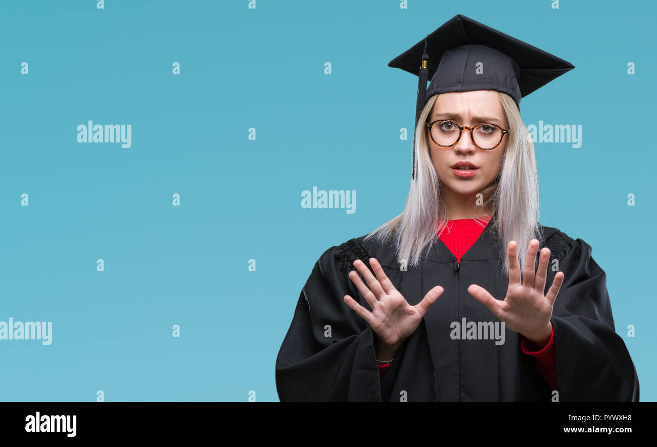 Young blonde woman wearing graduate uniform over isolated background ...