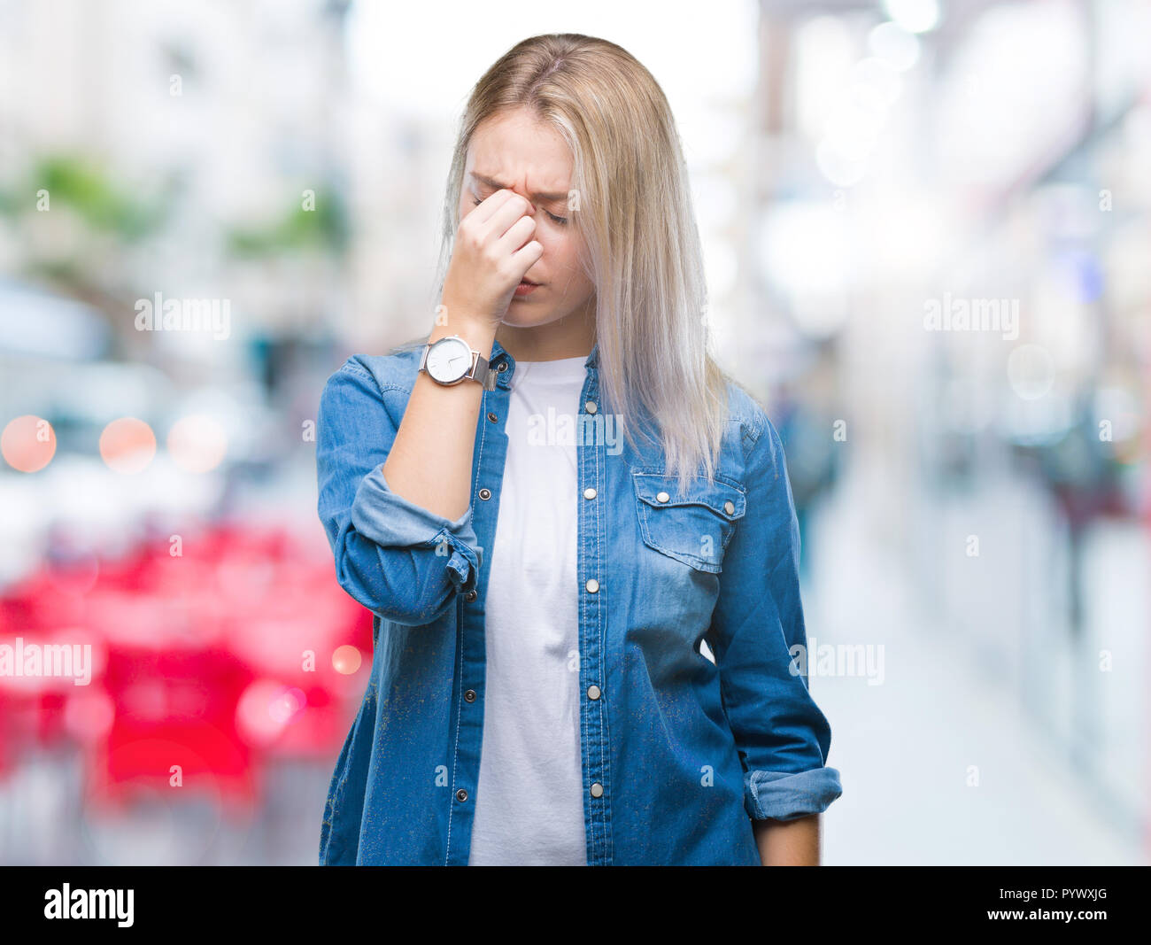 Young blonde woman over isolated background tired rubbing nose and eyes ...