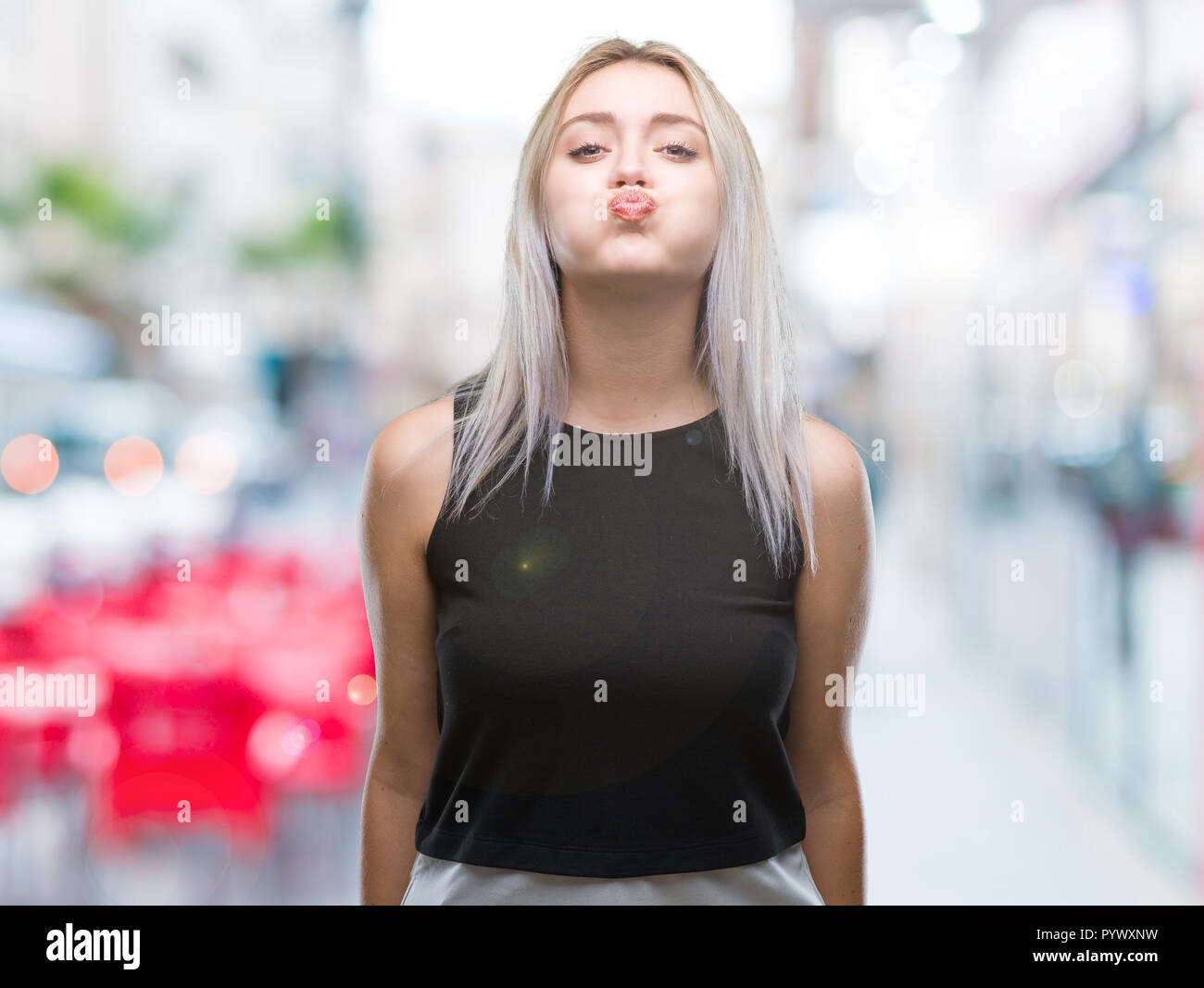 Young blonde woman over isolated background puffing cheeks with funny ...