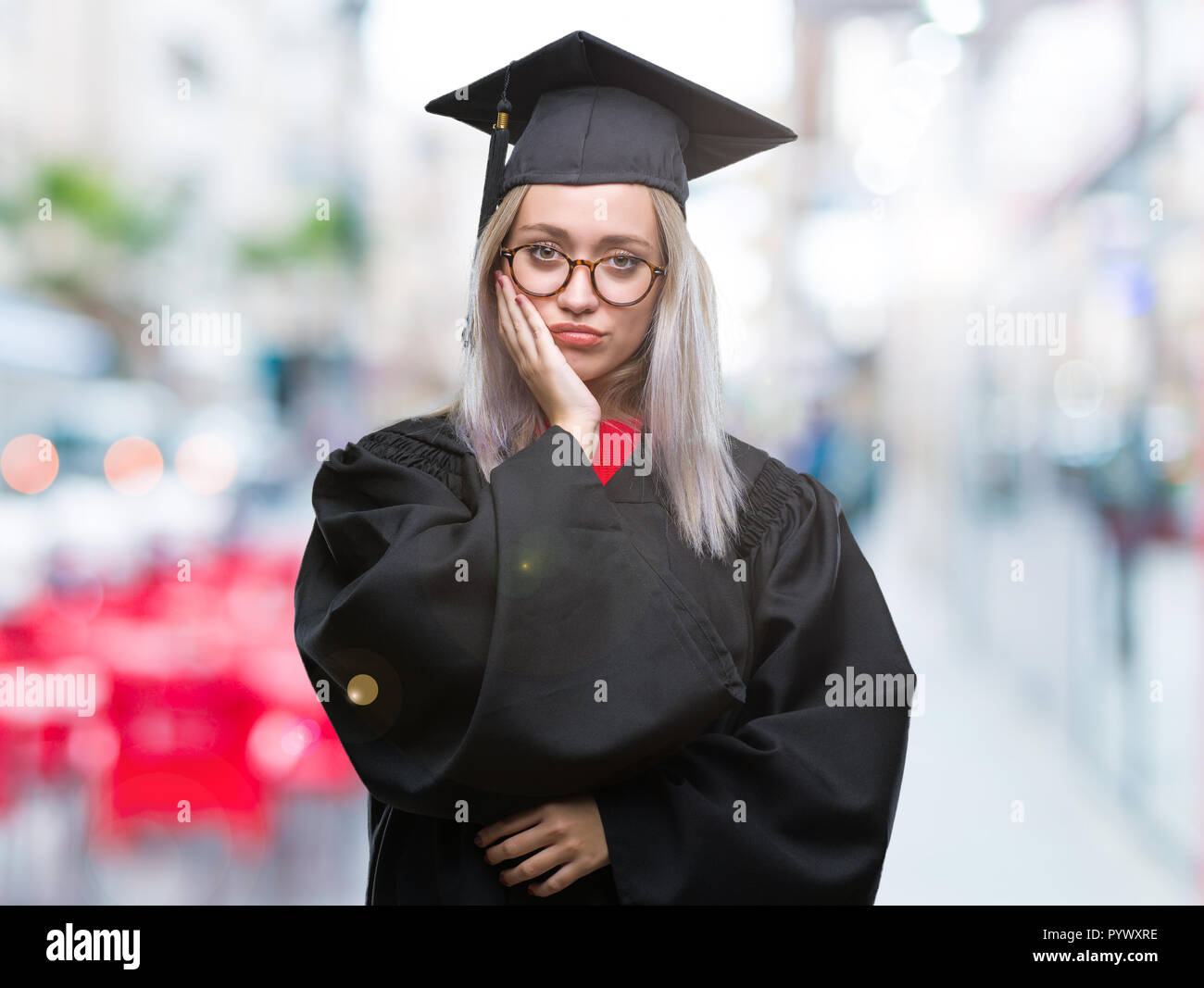 Young blonde woman wearing graduate uniform over isolated background ...