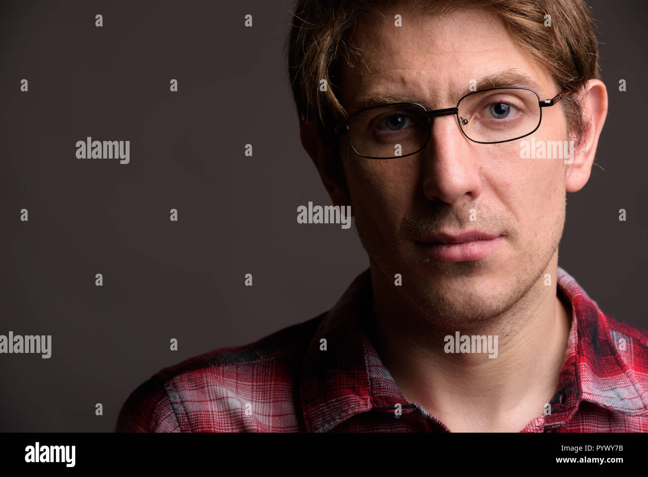 Handsome man wearing eyeglasses against gray background Stock Photo - Alamy