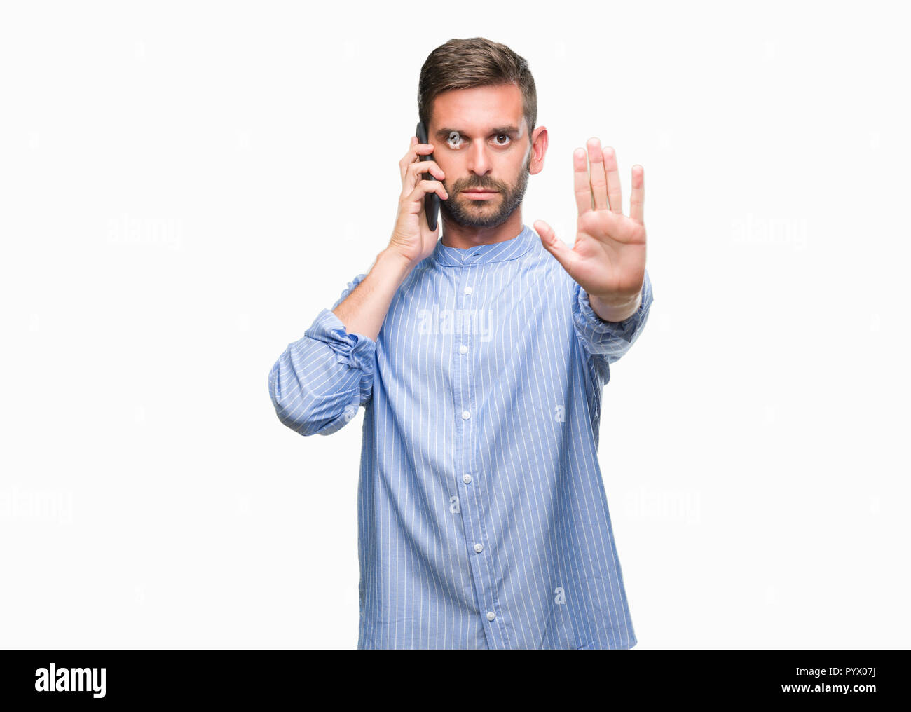 Young handsome man speaking on the phone over isolated background with ...