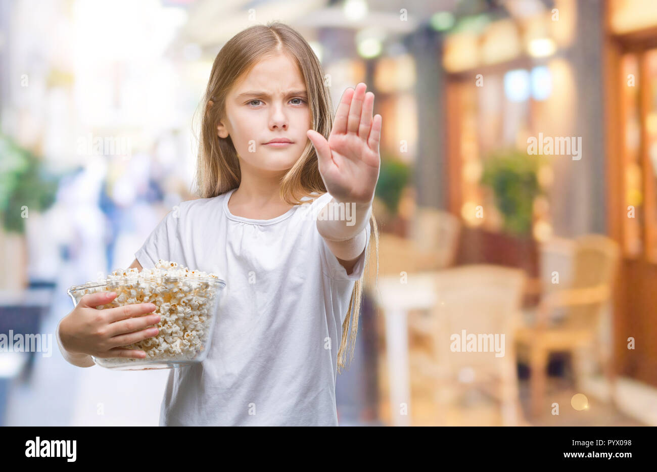 Young beautiful girl eating popcorn snack isolated background with open ...