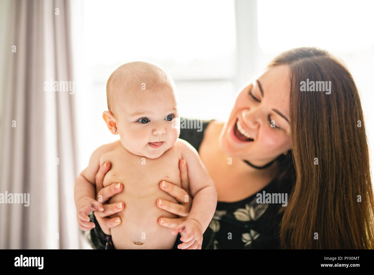 A Portrait of happy baby with cheerful mother at home bedroom Stock ...