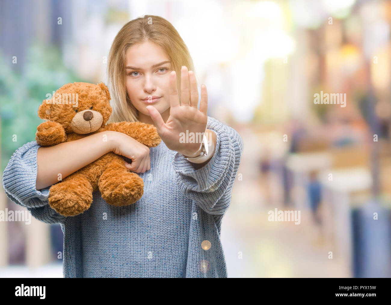 Young caucasian woman holding cute teddy bear over isolated background ...