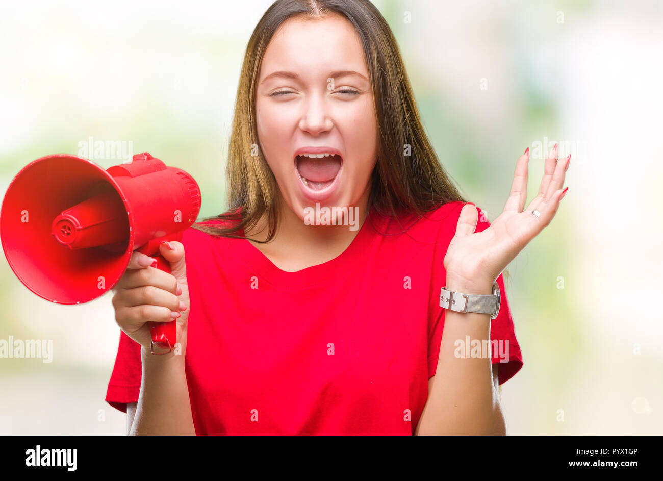 Young caucasian woman yelling through megaphone over isolated ...
