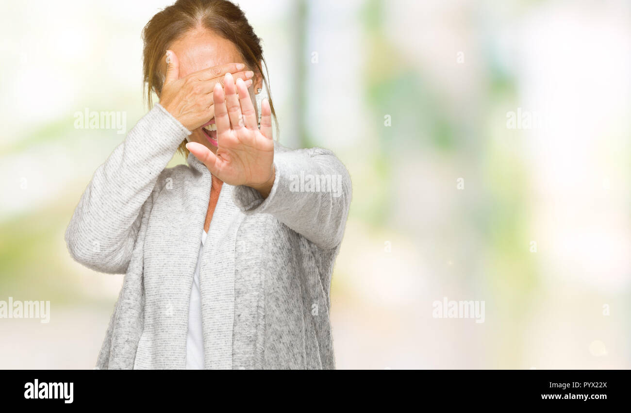 Beautiful middle age adult woman wearing winter sweater over isolated ...