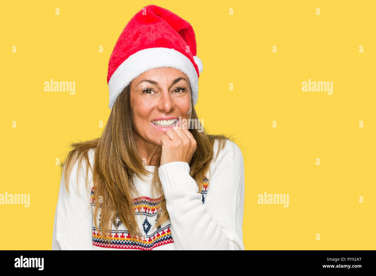 Middle age adult woman wearing winter sweater and chrismat hat over ...