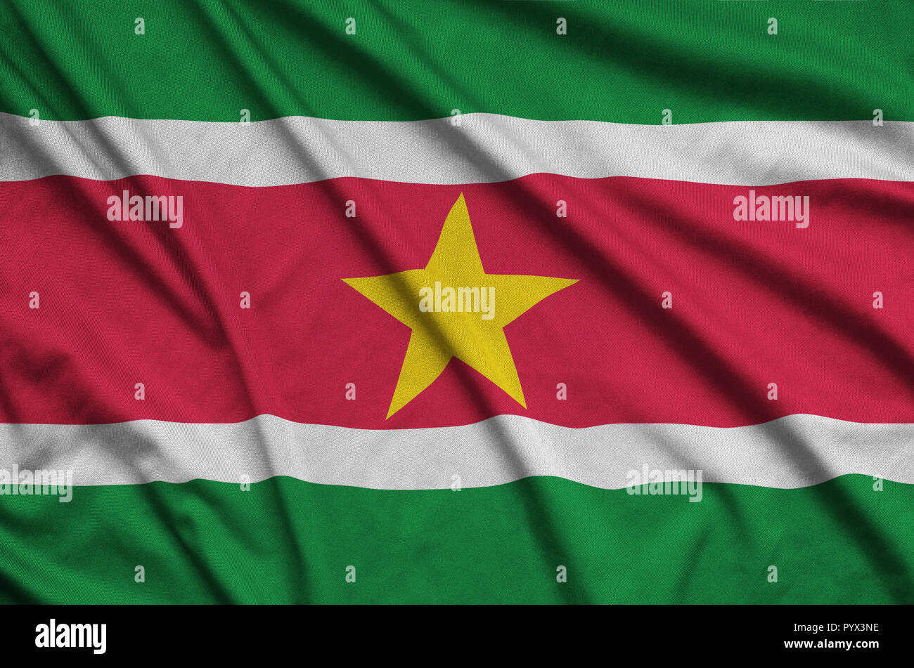 Suriname flag is depicted on a sports cloth fabric with many folds ...