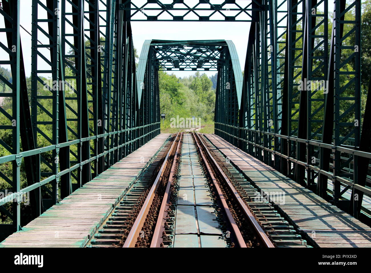 Green metal railway bridge construction with railway tracks connected ...