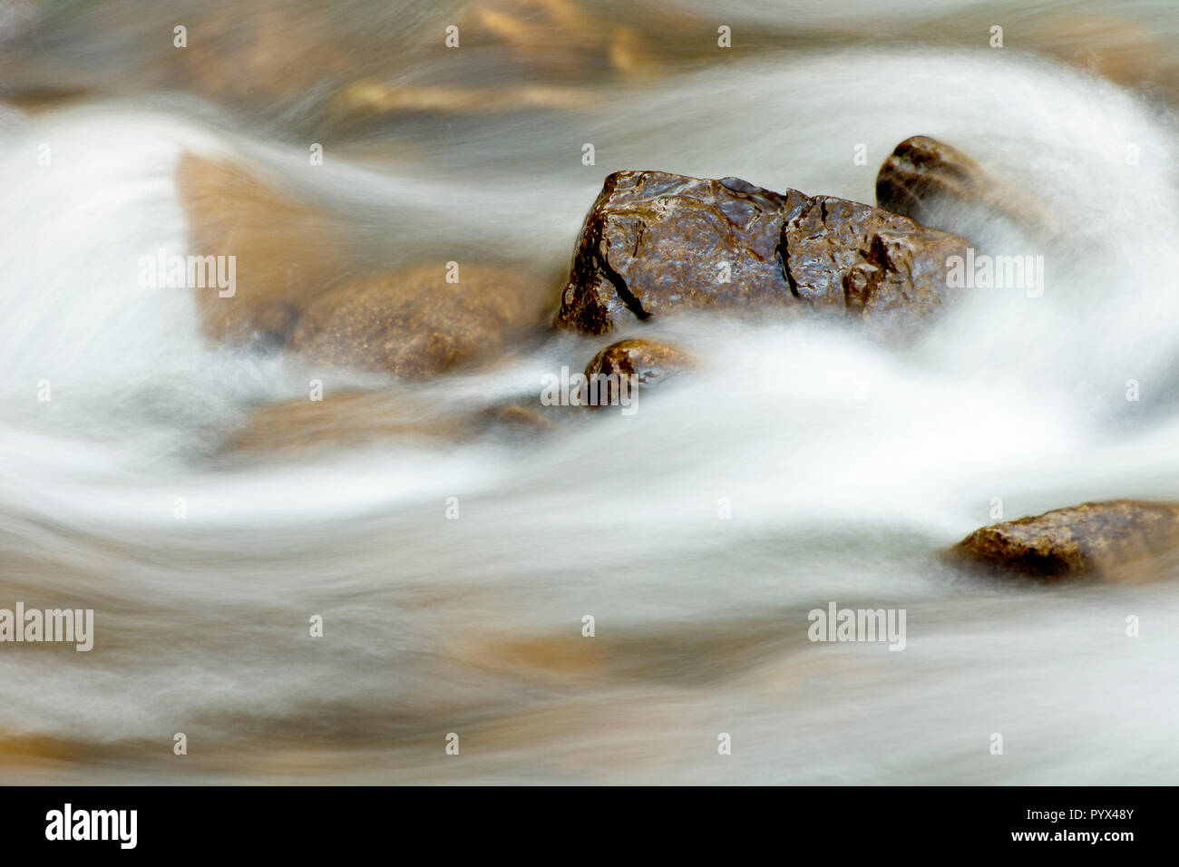Water flowing over rocks, caught with a slow shutter speed to blur the ...